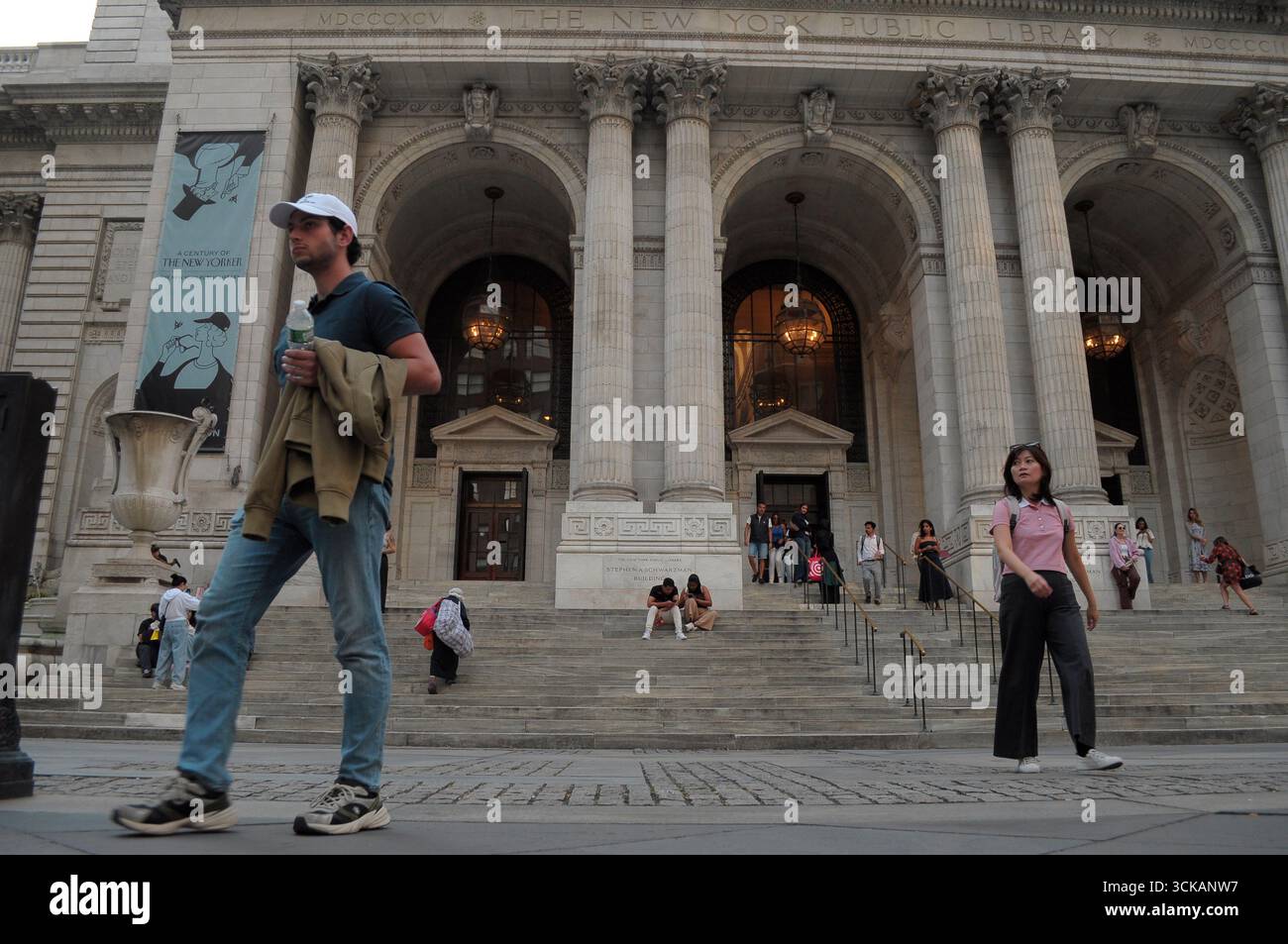 People walk down the stairs of the New York Public Library. (Photo by ...