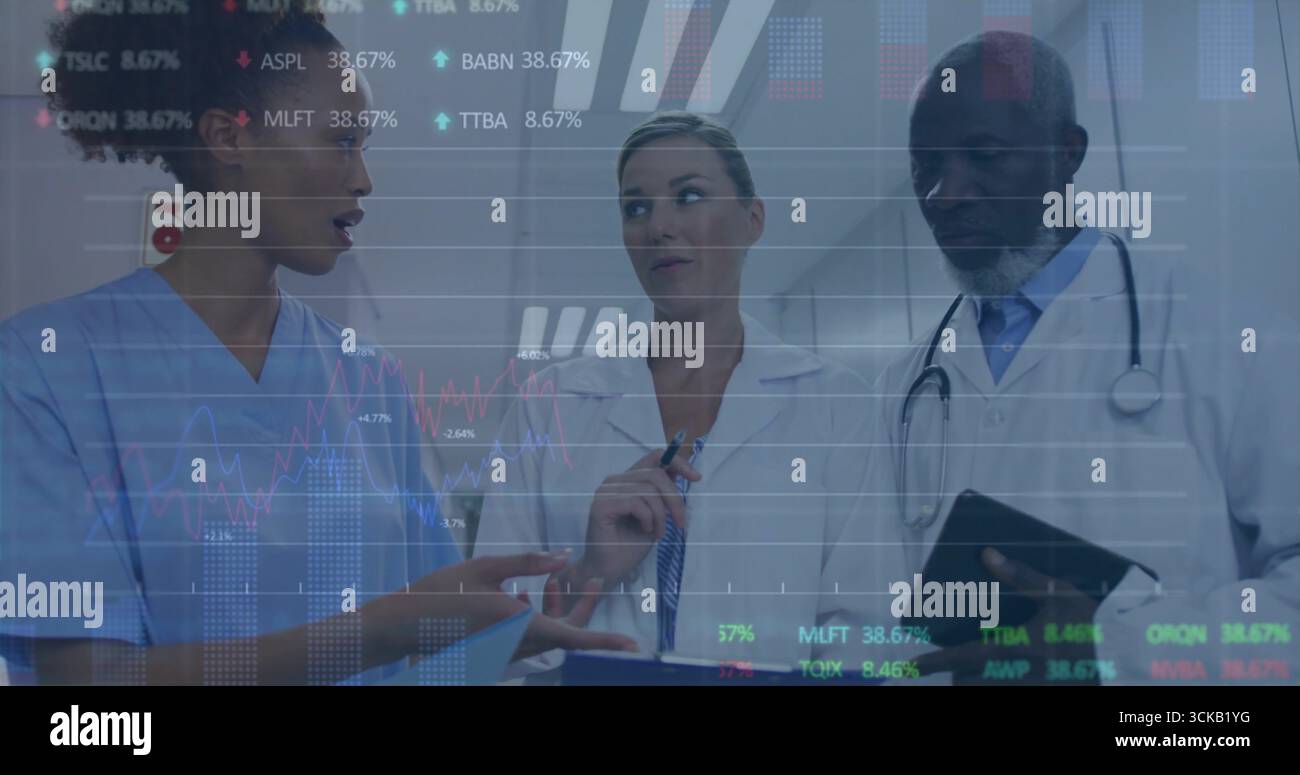 Collaborating medics reviewing digital charts on tablets in hospital ...