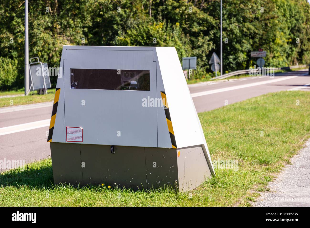 A mobile road safety camera is placed on the side of a busy road for ...