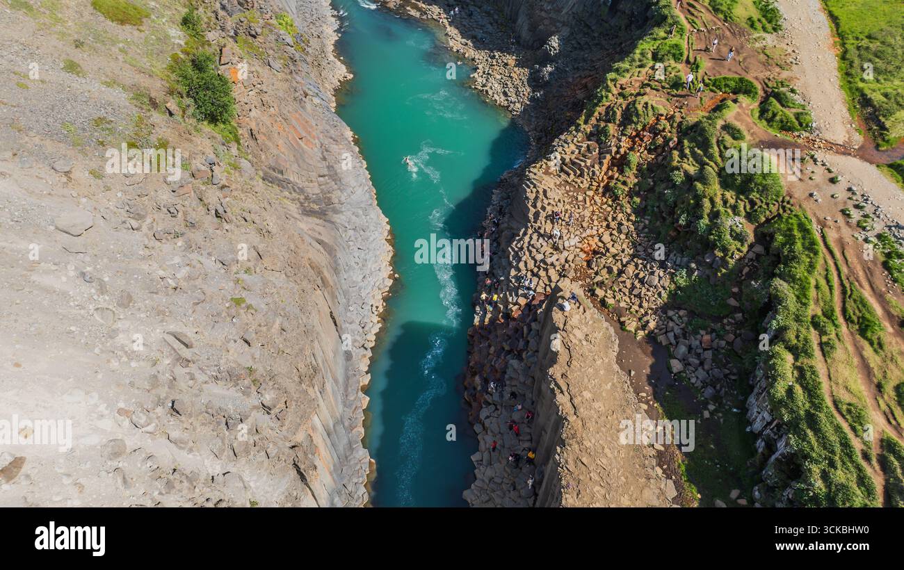 Turquoise river flows through a deep canyon with basalt rock walls ...