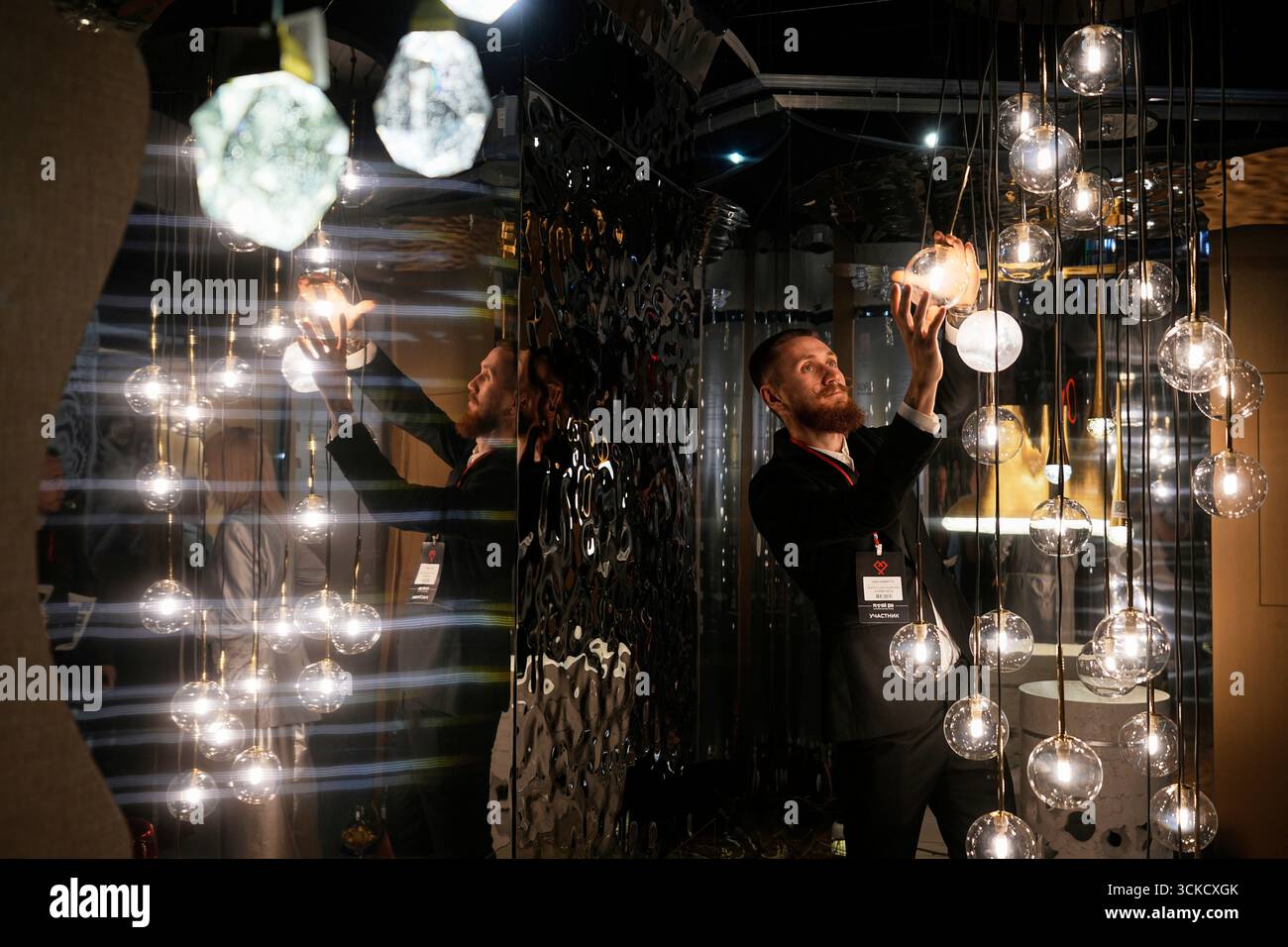 An exhibitor changes a light bulb at The Russian House interior design ...