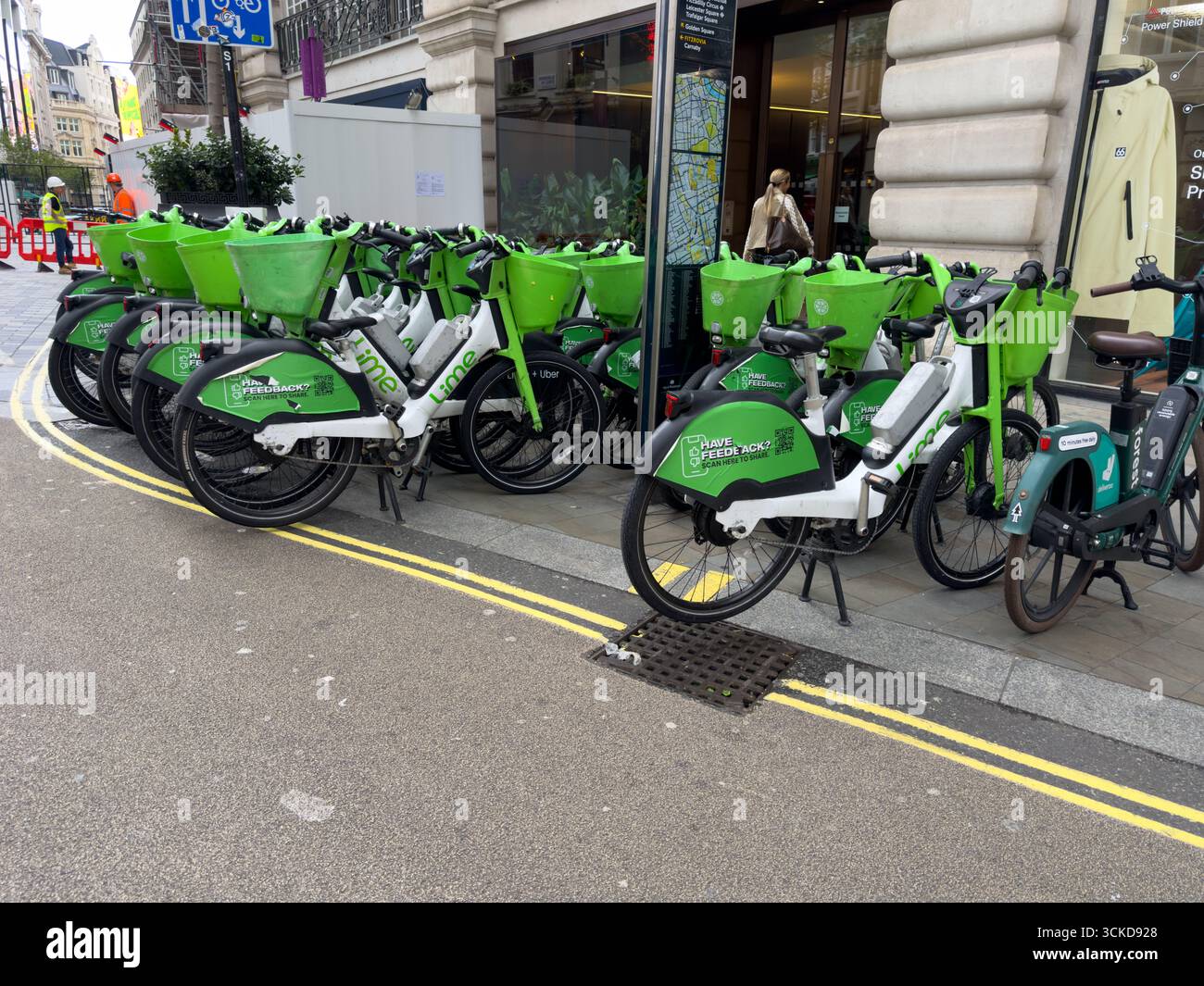 Group of Lime green electric hire bikes, bicycles parked at the side of ...