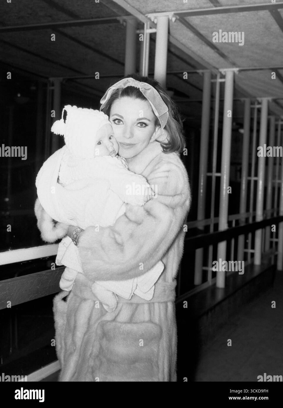 Actress Joan Collins holds her four month old daughter Tara as she ...