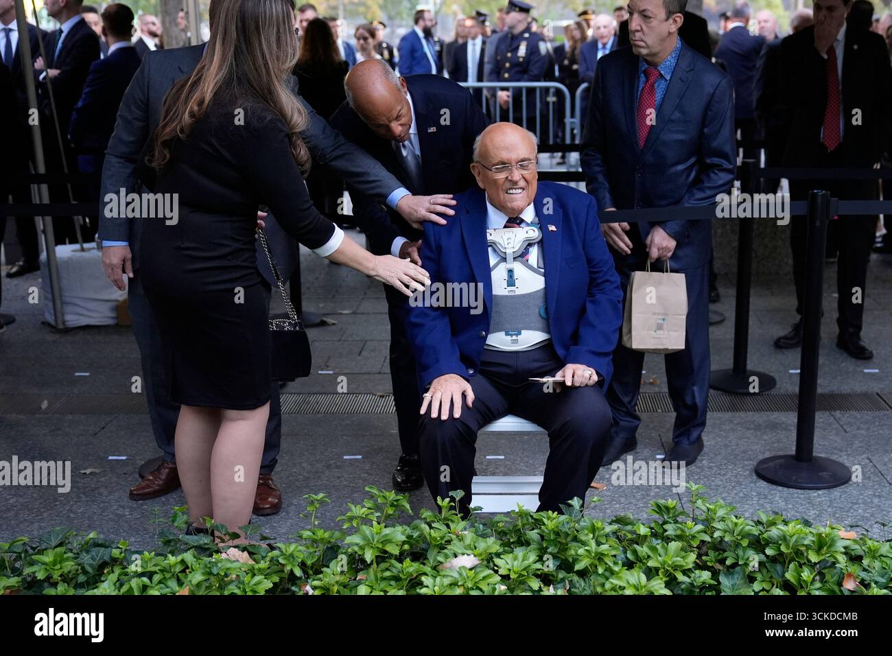 Former NYC mayor Rudy Giuliani sits in a chair wearing a brace before a ...