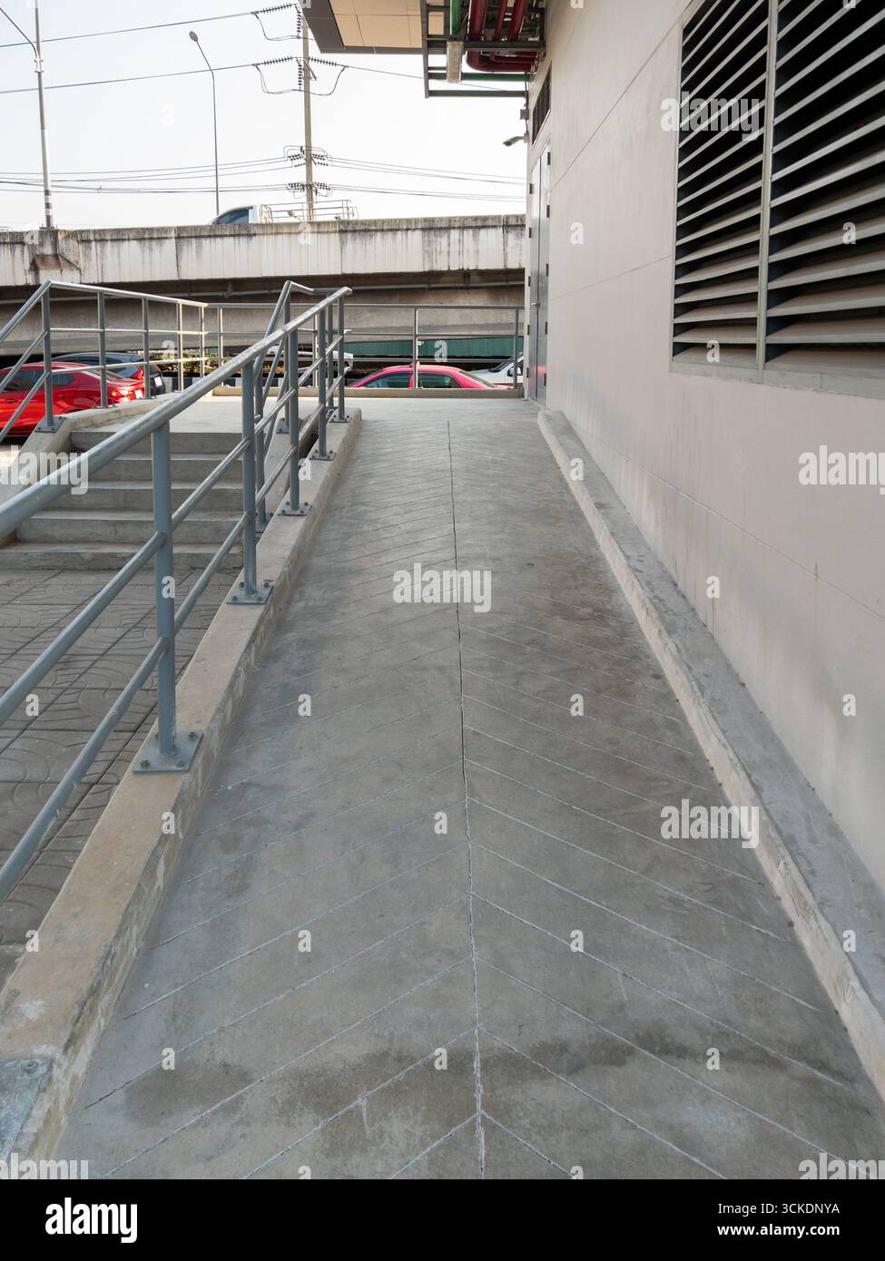 A concrete ramp and staircase leading to an electrical control building ...