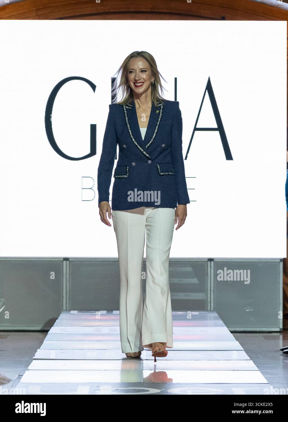 Lucy Lang, Inspector General wearing dress by Gina Newman walks runway ...