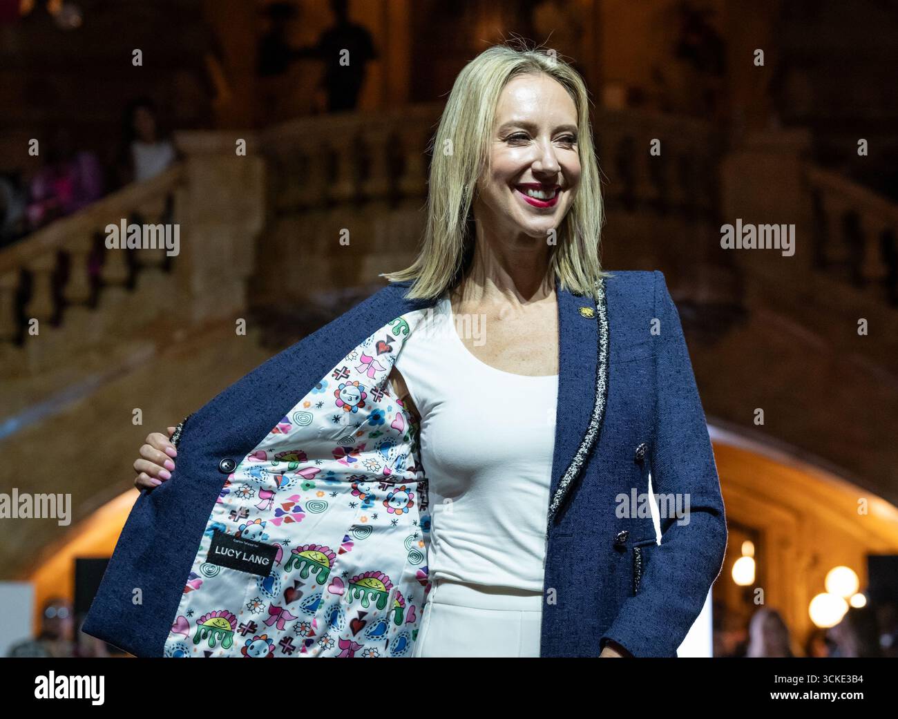 Lucy Lang, Inspector General wearing dress by Gina Newman walks runway ...