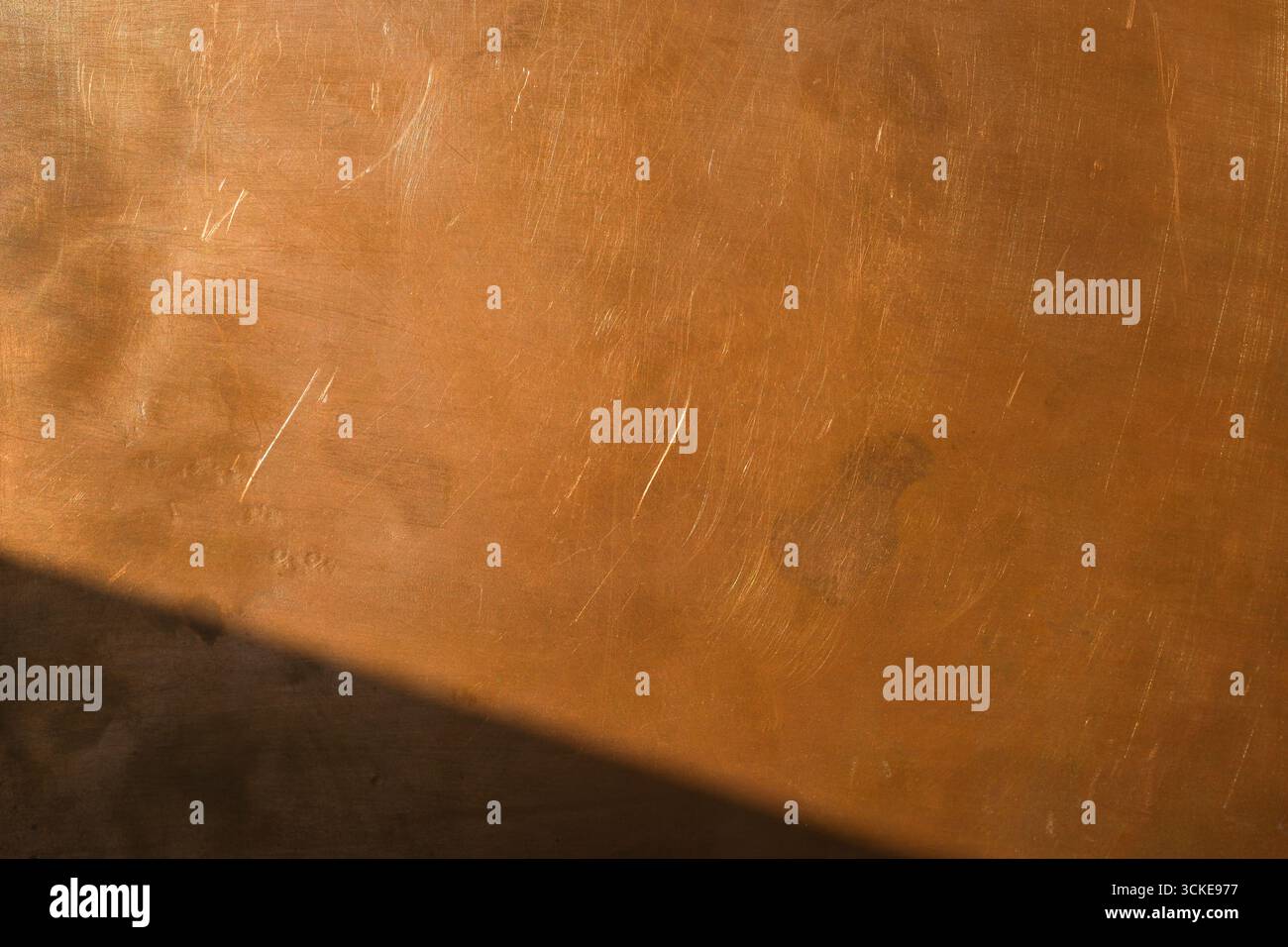 Copper surface in sunlight, with deep shadow in the lower left corner ...
