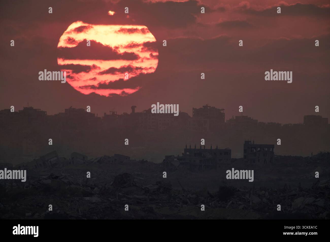 The sun sets behind buildings destroyed during Israeli ground and air ...