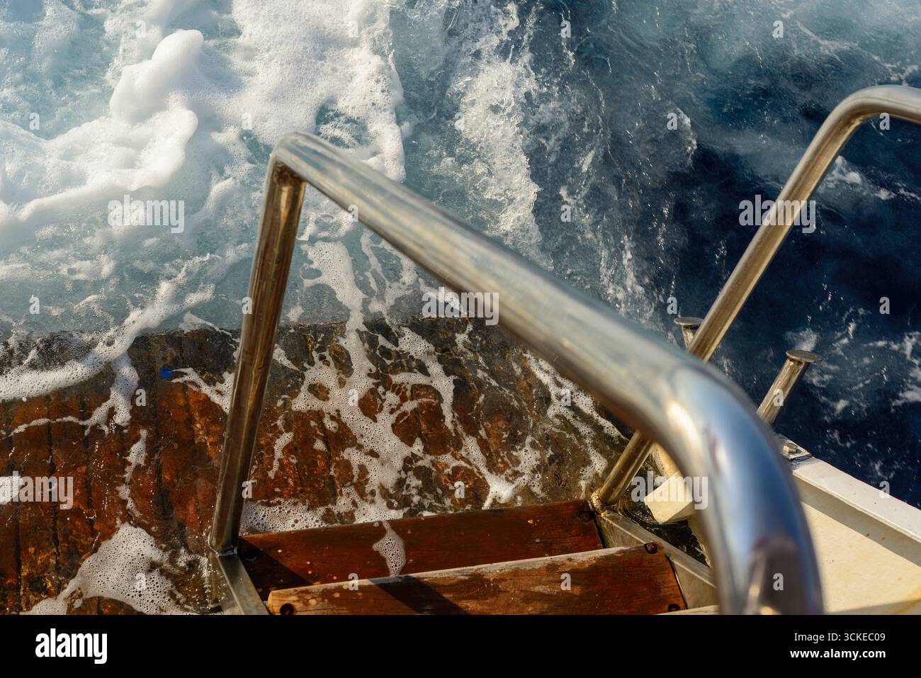 Wooden steps at metal handrail at the stern (back) of a boat leading ...