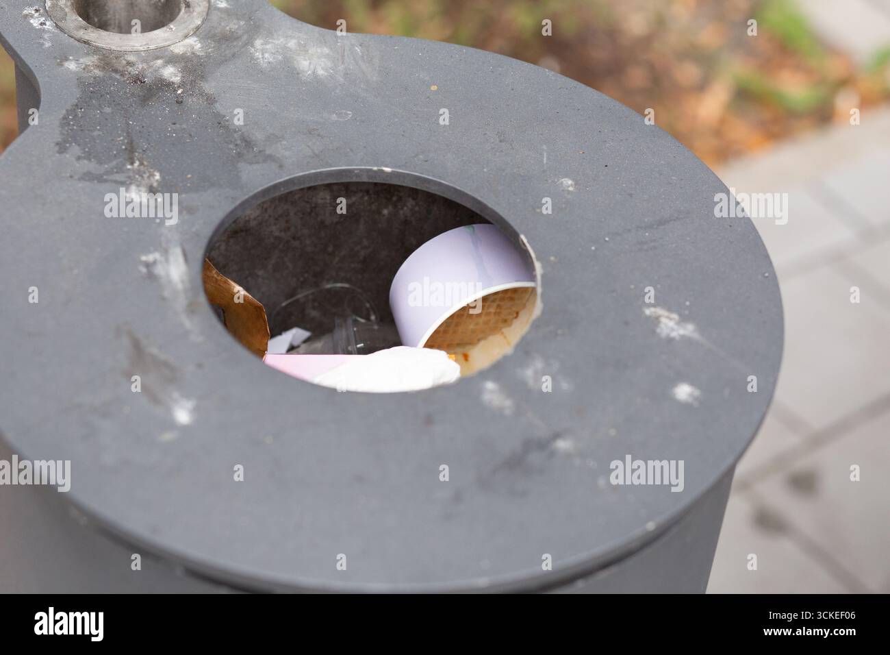 Trash bin filled with disposable cups, including a visible waffle ice ...
