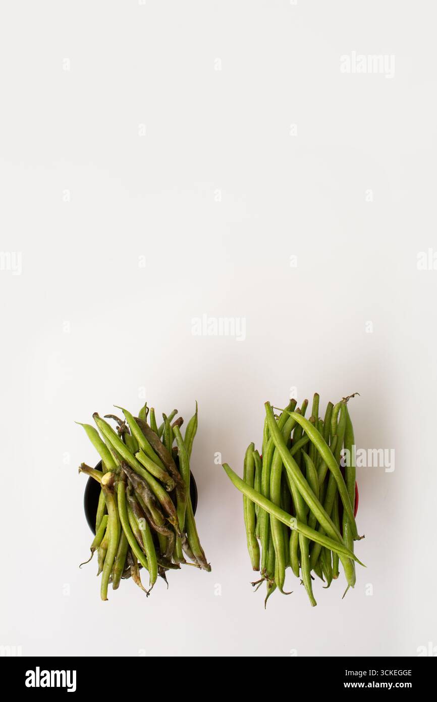 Flat lay of two bowls with green beans, fresh beans on the right ...