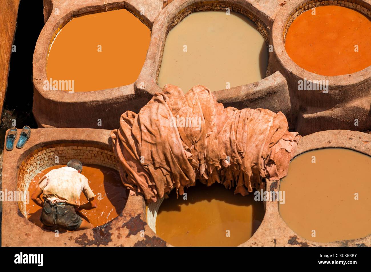 Moroccan tannery worker in a dye vat - An overhead view of a worker ...