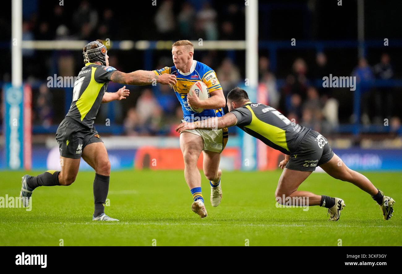 Leeds Rhinos' Lachlan Miller (centre) is tackled by Catalans Dragons ...