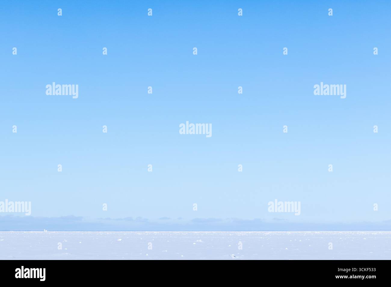 Open expanse of snowy terrain under a vivid blue sky with soft ...