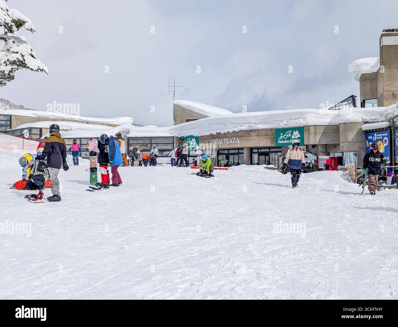 Group of snowboarders and skiers at the Escal Plaza in Hakuba Goryu ski ...