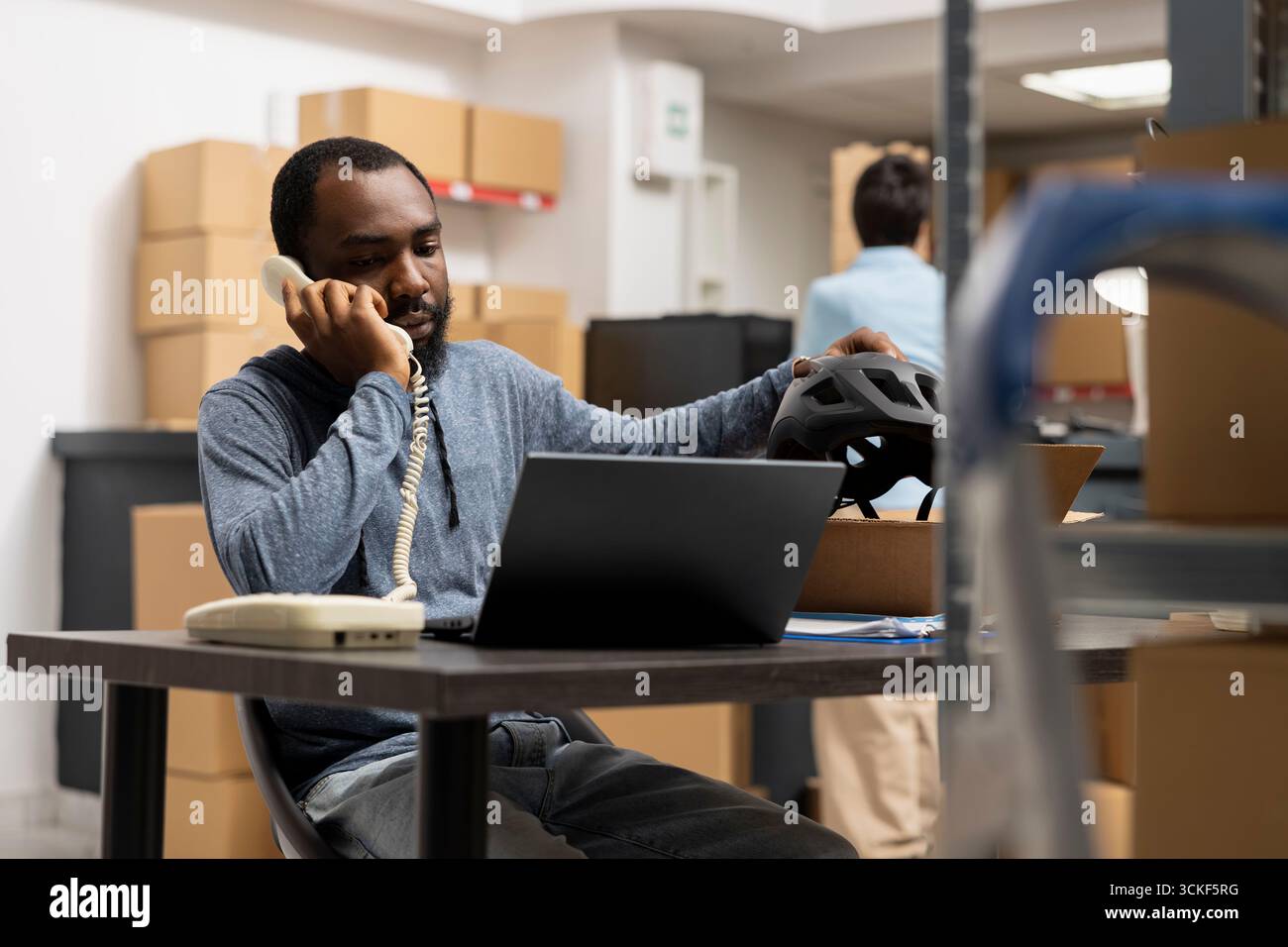 Male employee answering landline phone call with the dispatch, managing ...