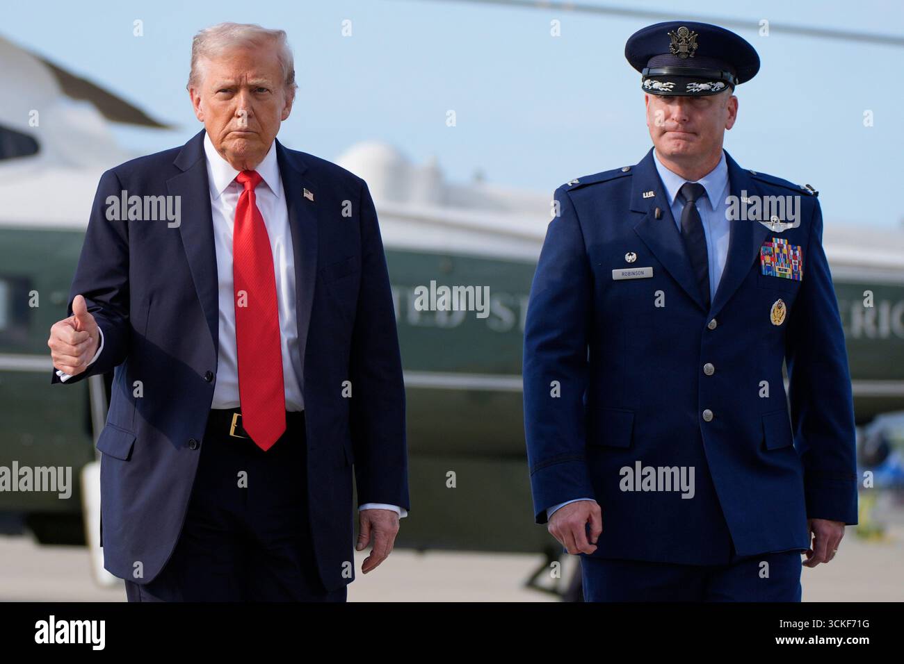 President Donald Trump walks with Col. Christoper Robinson, commander ...