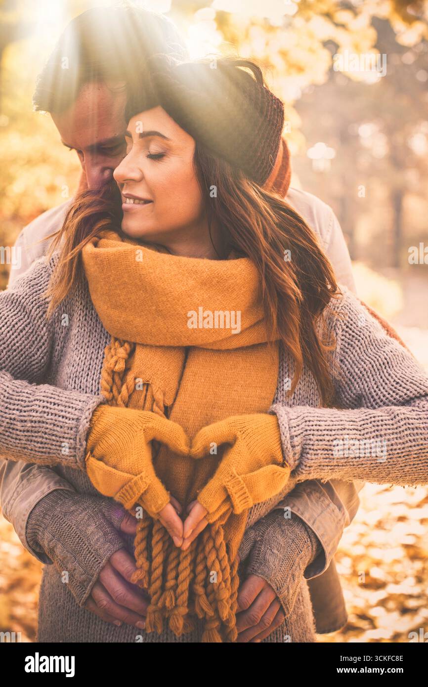 man hugging his partner and forming a heart with his hands Stock Photo ...