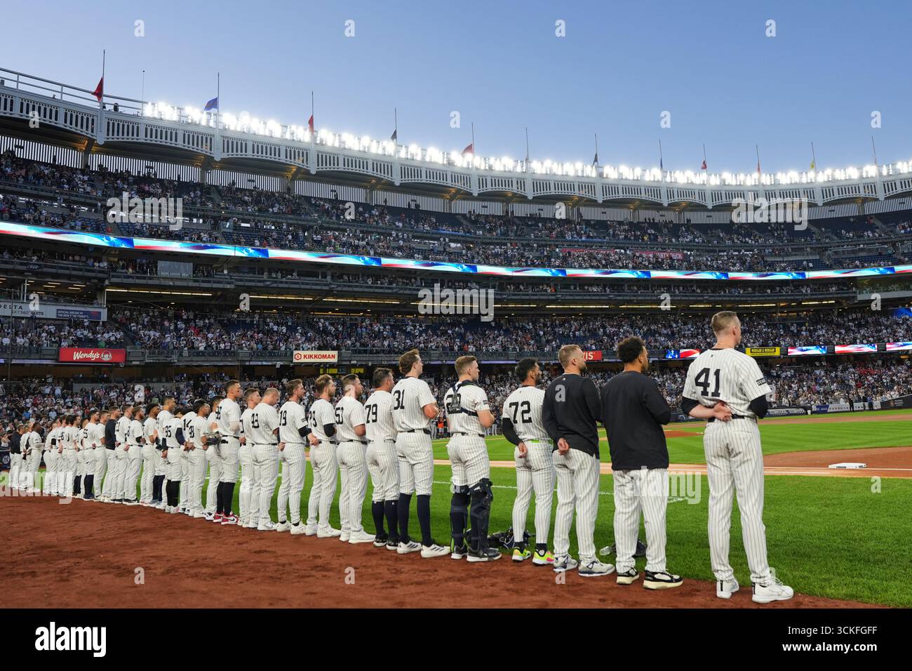 The New York Yankees and the Detroit Tigers stand on the field before a ...