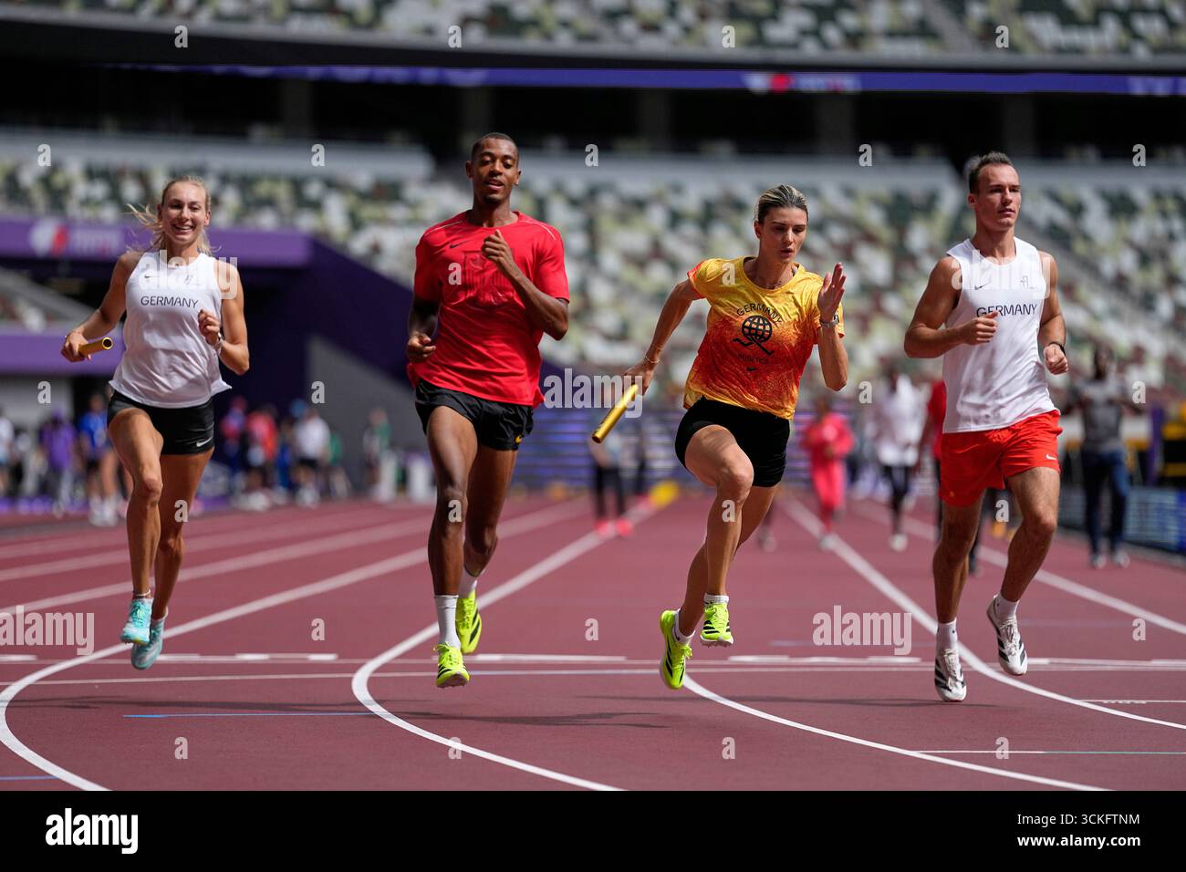 German runners warm-up on the track as they practice on the eve of the ...