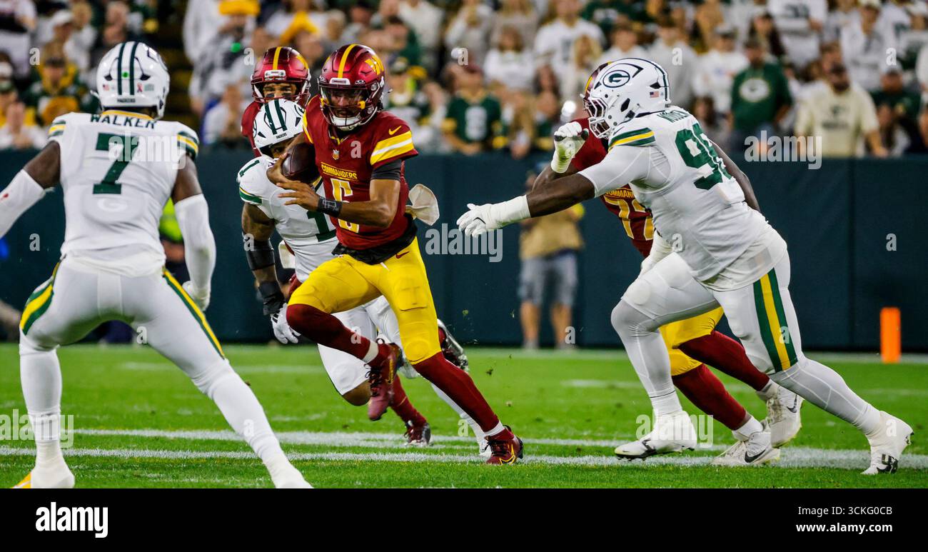 Washington Commanders quarterback Jayden Daniels (C) scrambles between ...
