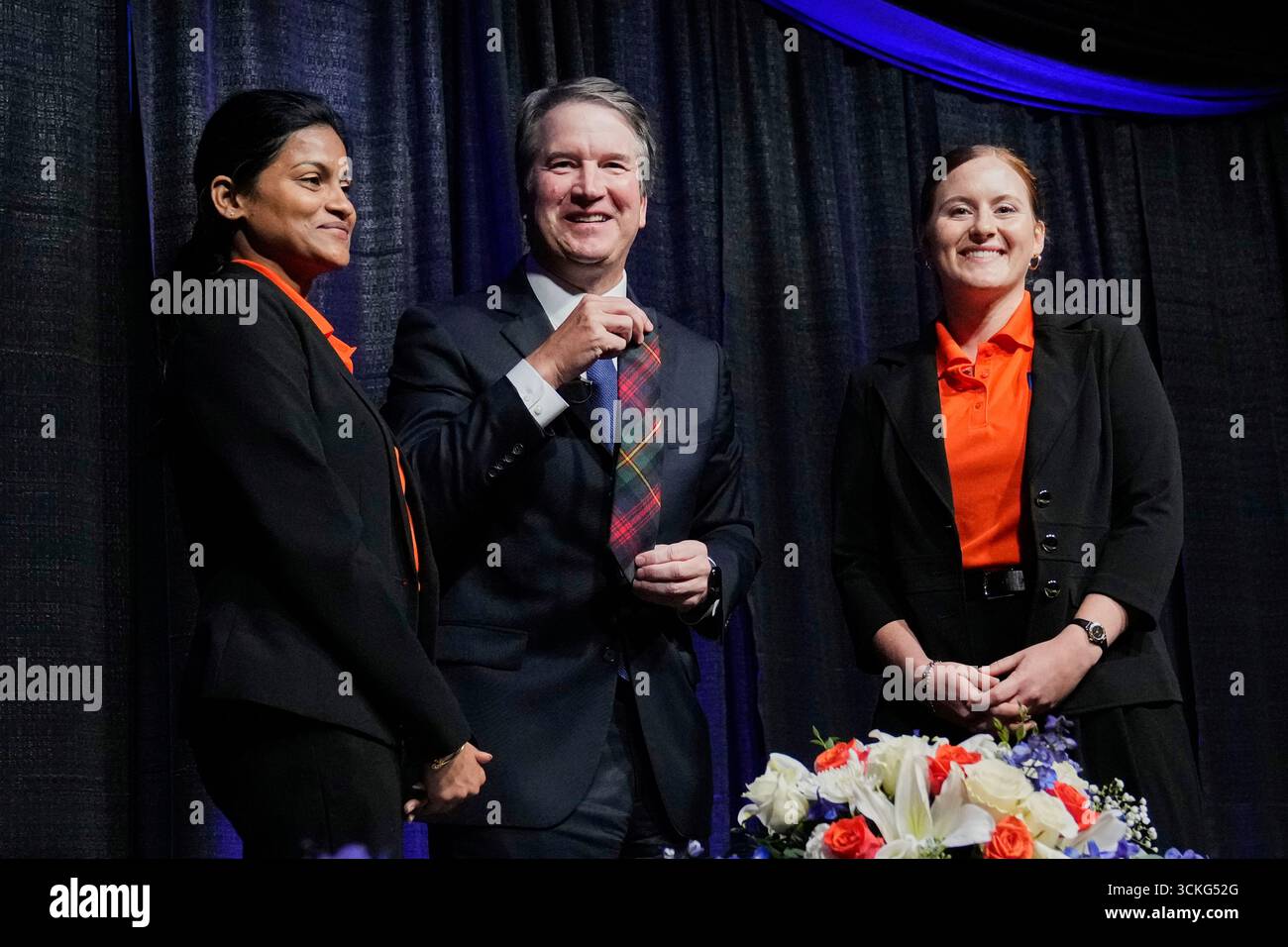 Justice Brett Kavanaugh, center, holds up a gift he was presented by ...