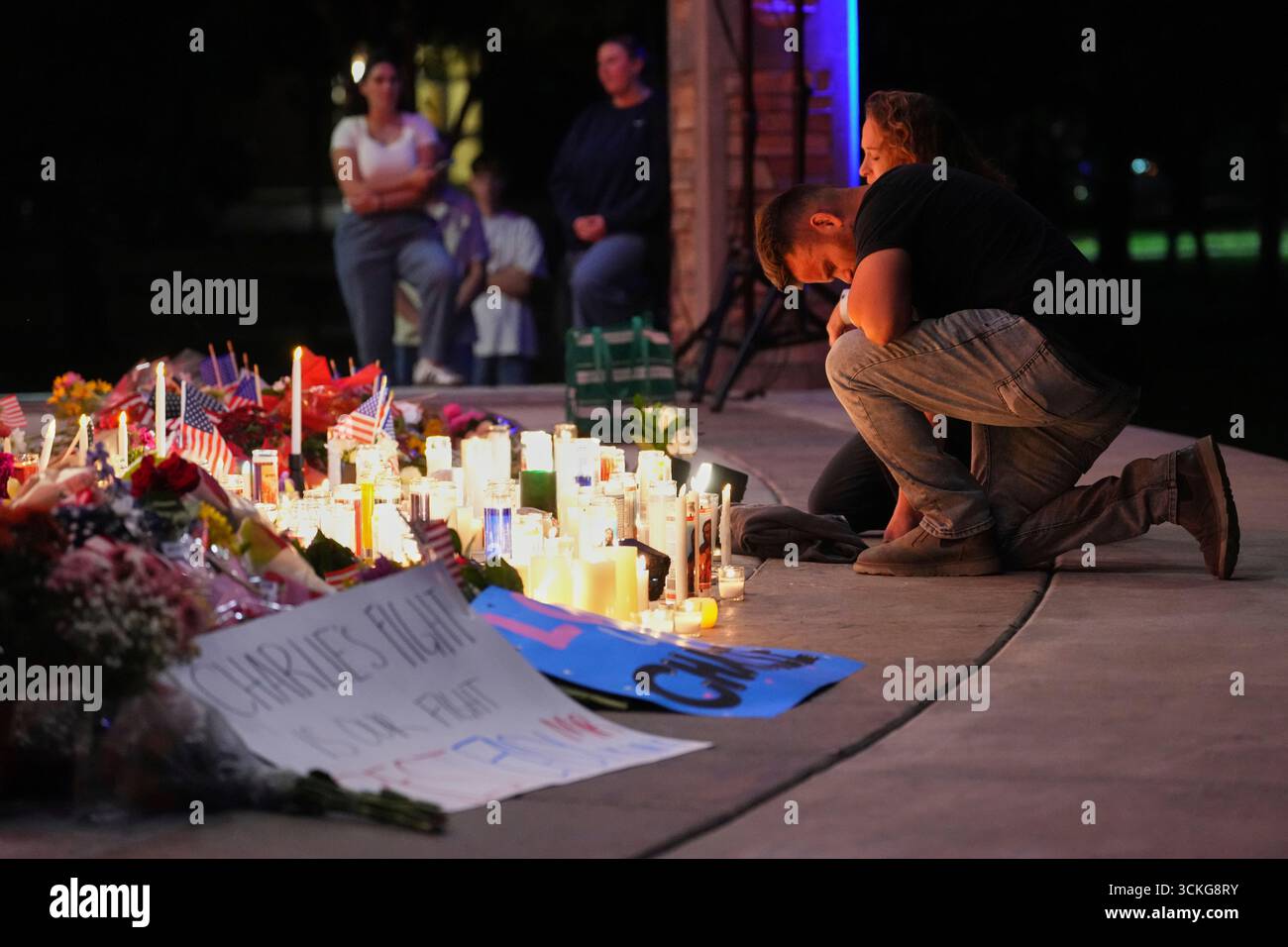A man kneels during a vigil for Charlie Kirk, the CEO and co-founder of ...