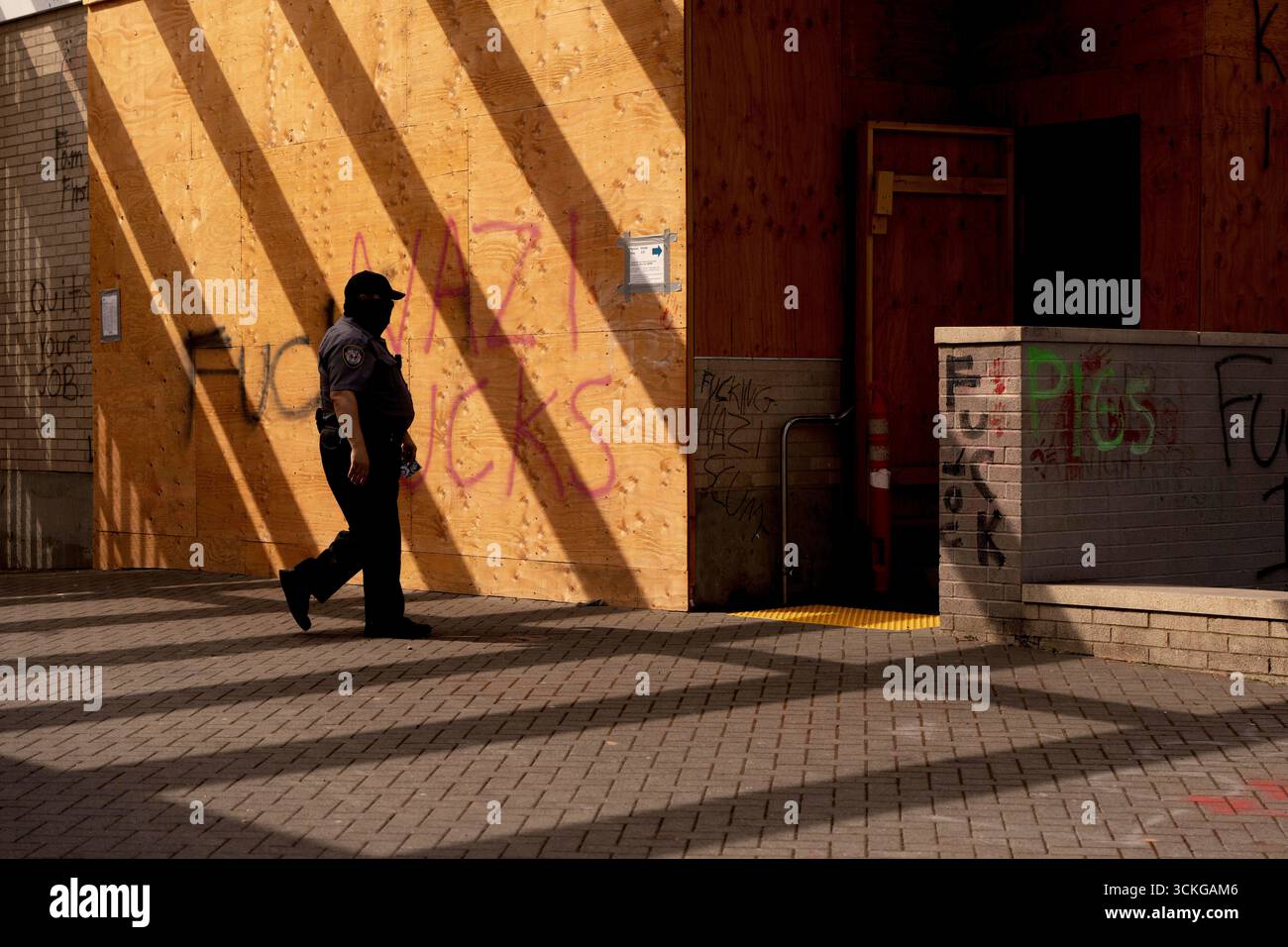 EDS NOTE: OBSCENITY - A security guard walks past graffiti outside the ...