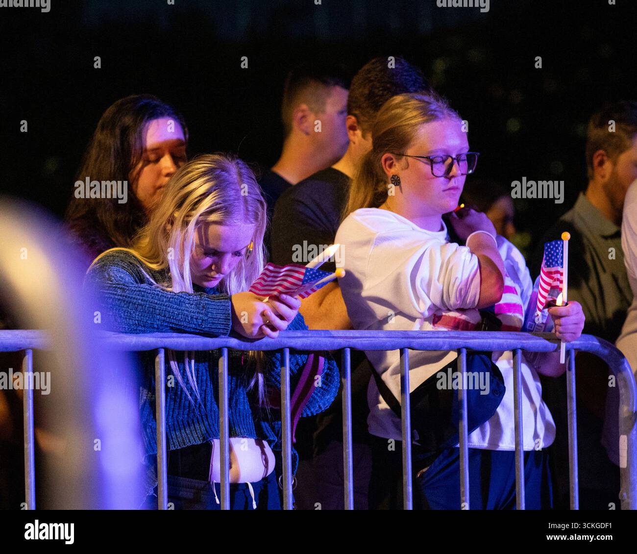 Attendees bow their heads in prayer during a vigil for Charlie Kirk at ...