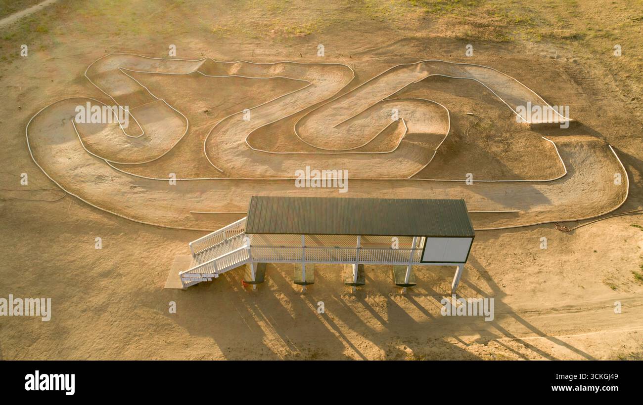 A dirt track with a ramp and a small building in the background. The ...