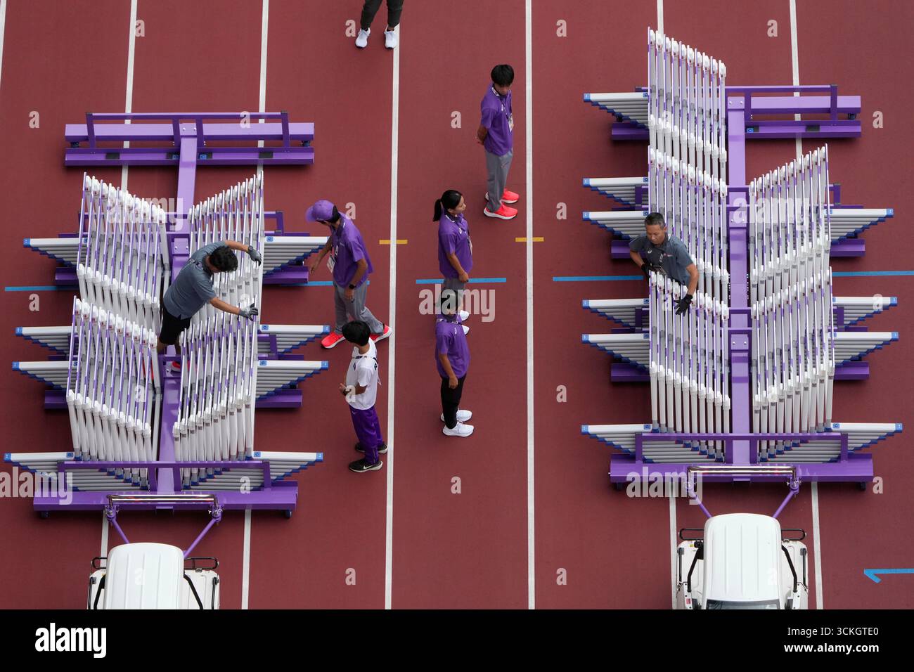 Workers practice removing hurdles from the track ahead of the World ...