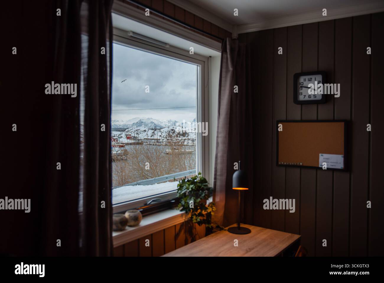 Cozy room with a view of snowy mountains through a window Stock Photo ...