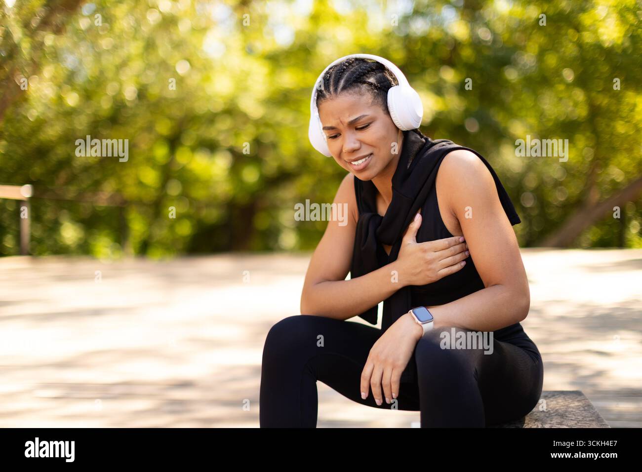 Worried black woman touching chest with hand outdoors, showing ...