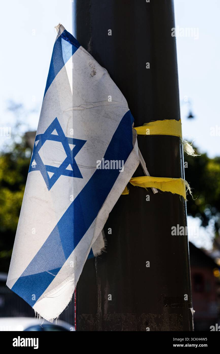 An Israeli flag and yellow ribbons tied to a pole in Jerusalem as a ...