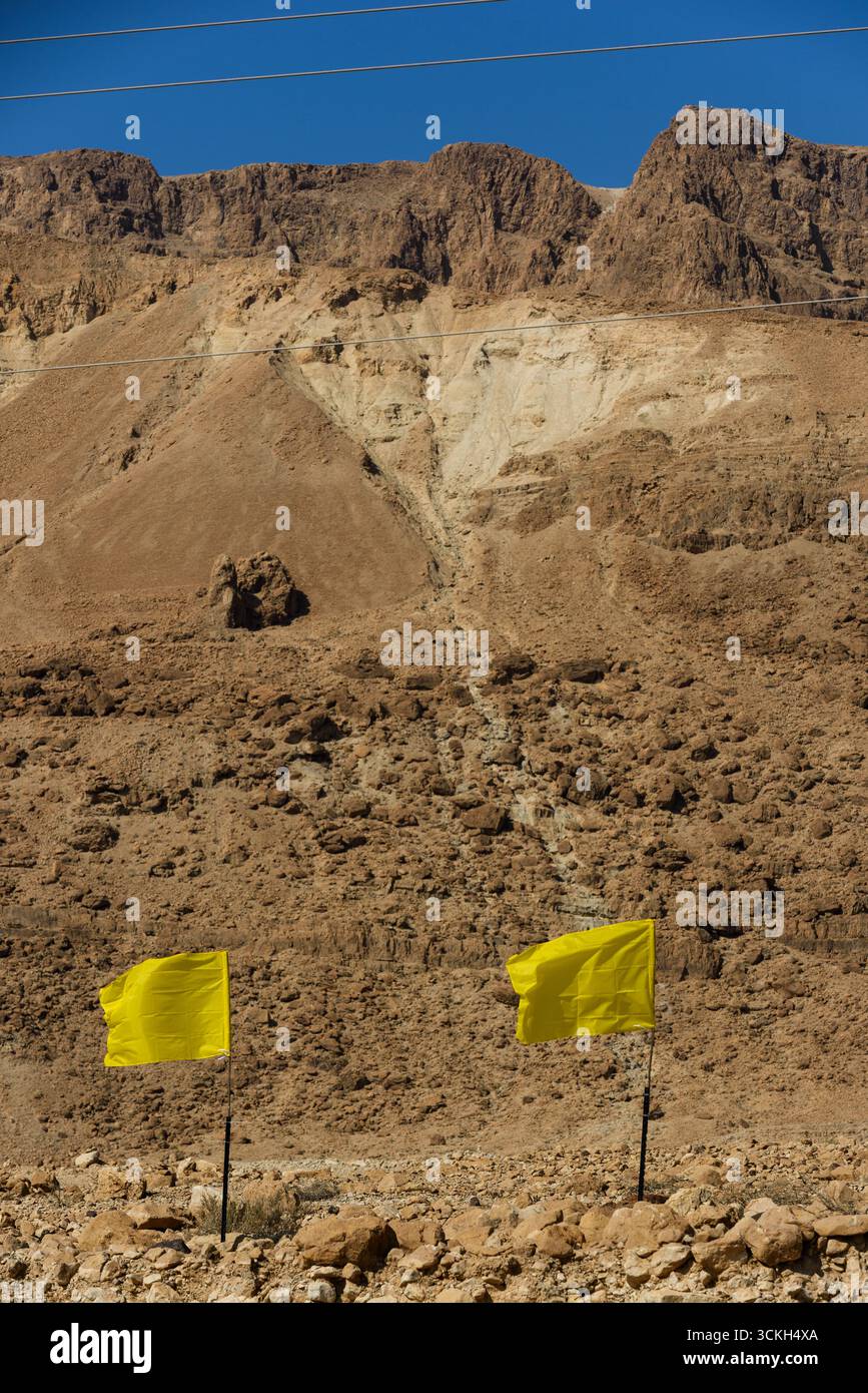 Yellow flags planted in the desert on the highway along the Dead Sea ...