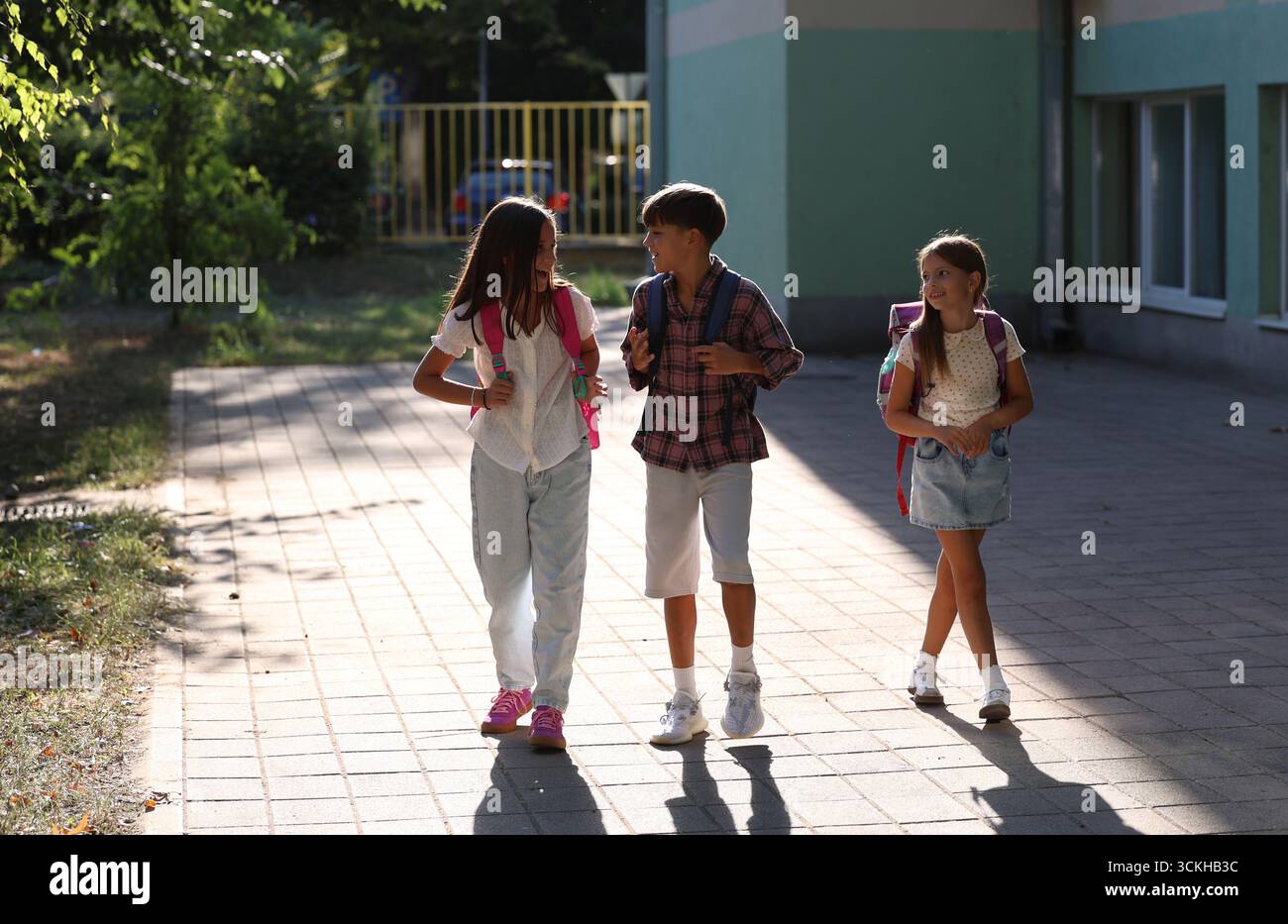 Three children walk happily hi-res stock photography and images - Alamy