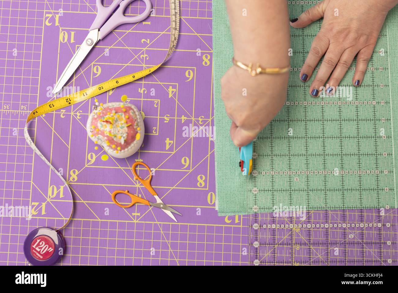 Overhead view of woman cutting fabric Stock Photo - Alamy