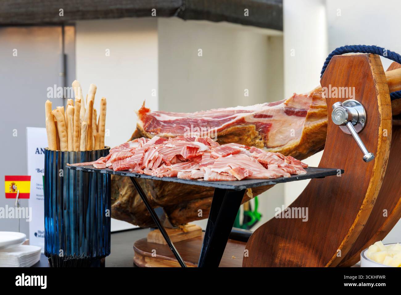 Whole Iberian ham shoulder and slices with breadsticks arranged on a ...