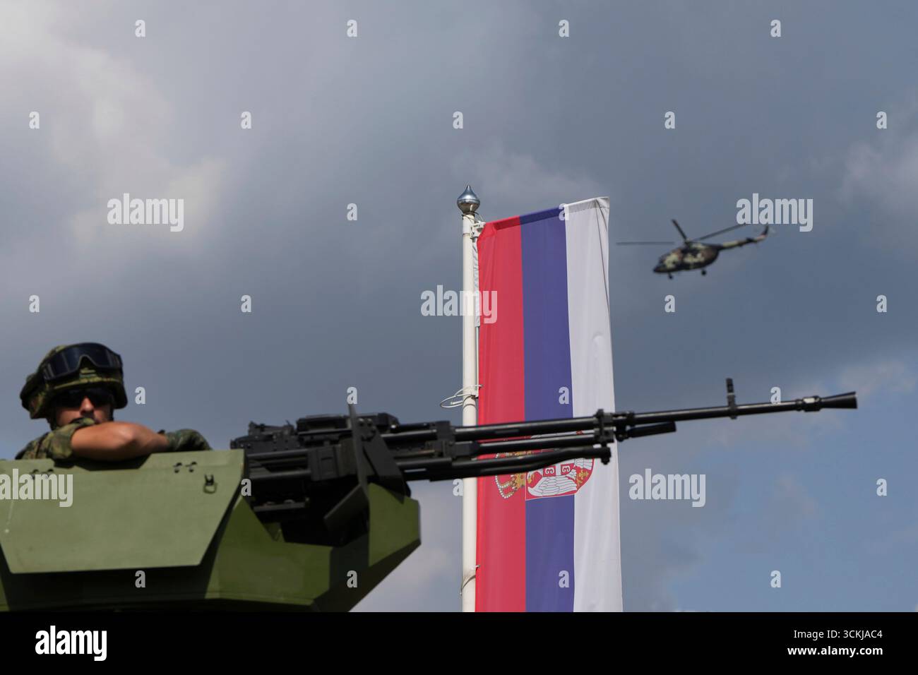 A Serbian soldier sits on top of an armored vehicle ahead of a military ...
