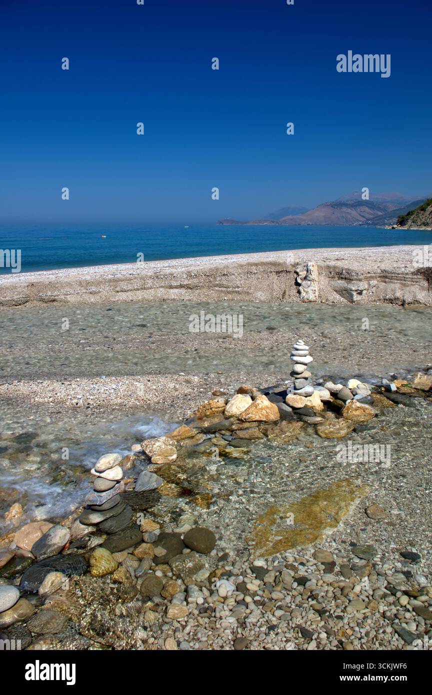 Pile di sassi in equilibrio lungo un ruscello di acqua limpida nella ...