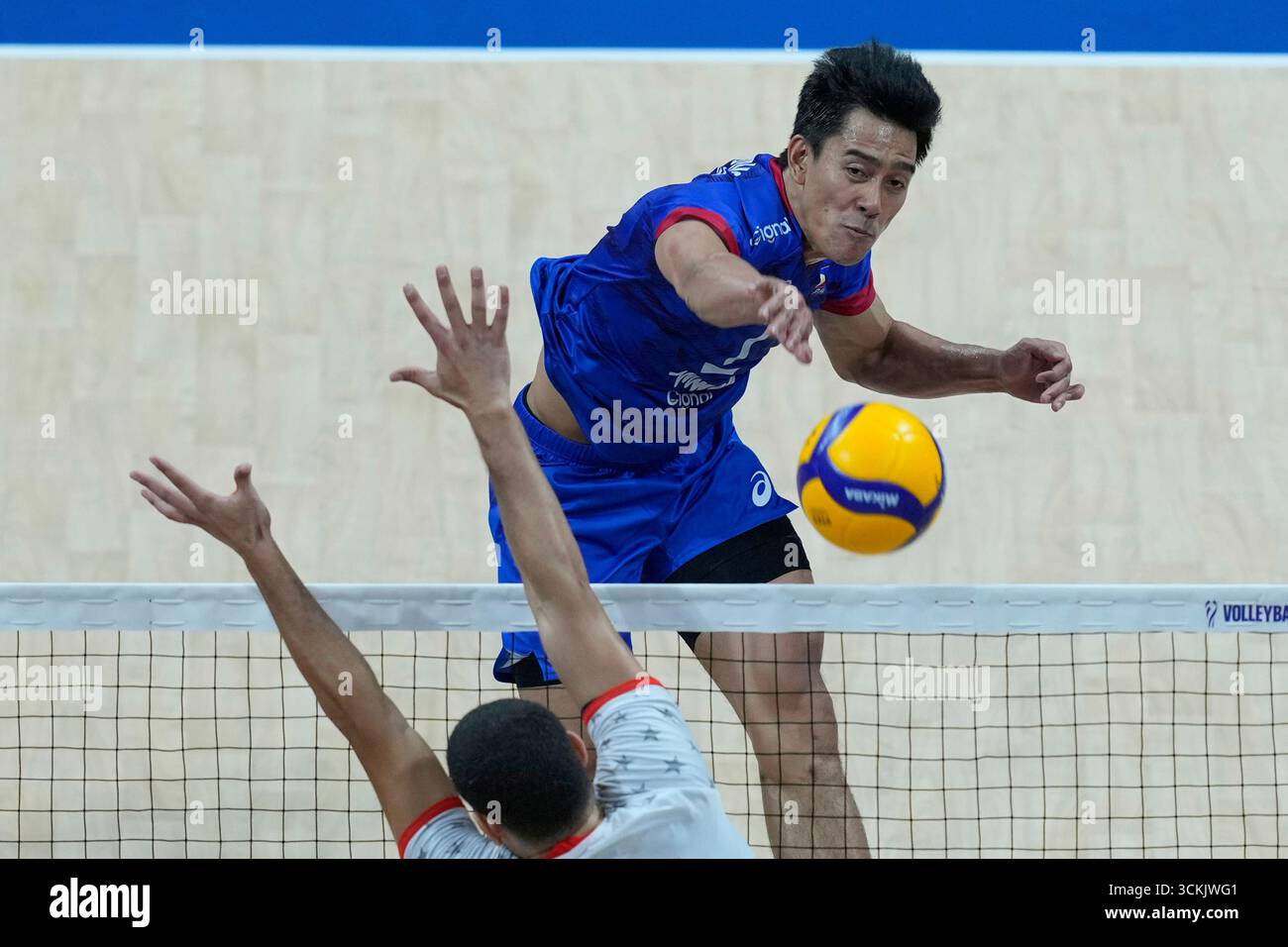 Bryan Bagunas of the Philippines spikes the ball agianst Selim Mbareki ...