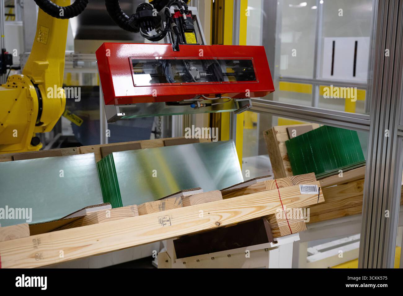 A robot stacks lengths of glass during a tour of Corning's iPhone glass ...