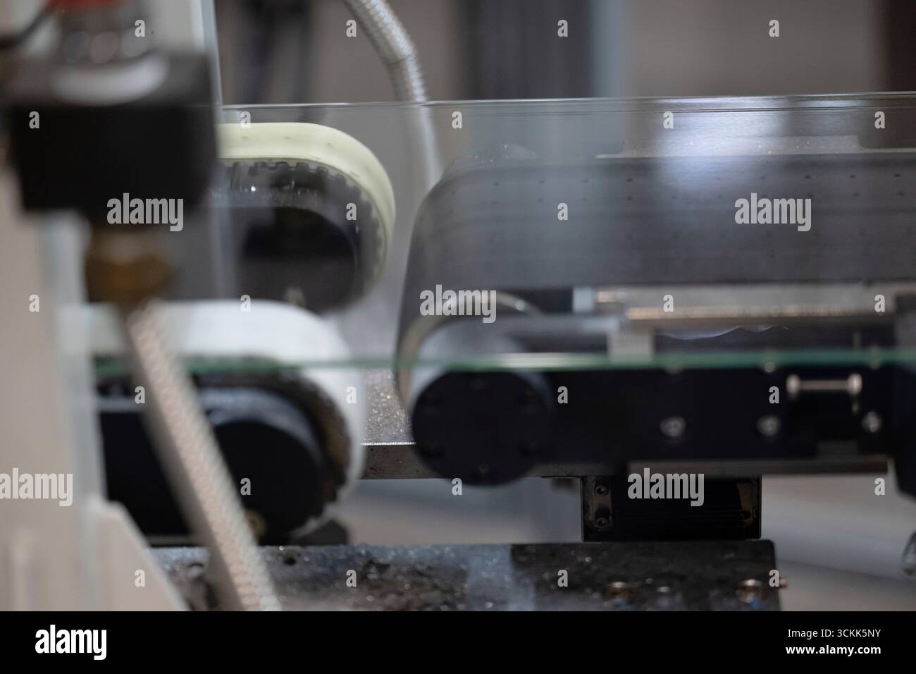A length of glass moves through a machine during a tour of Corning's ...