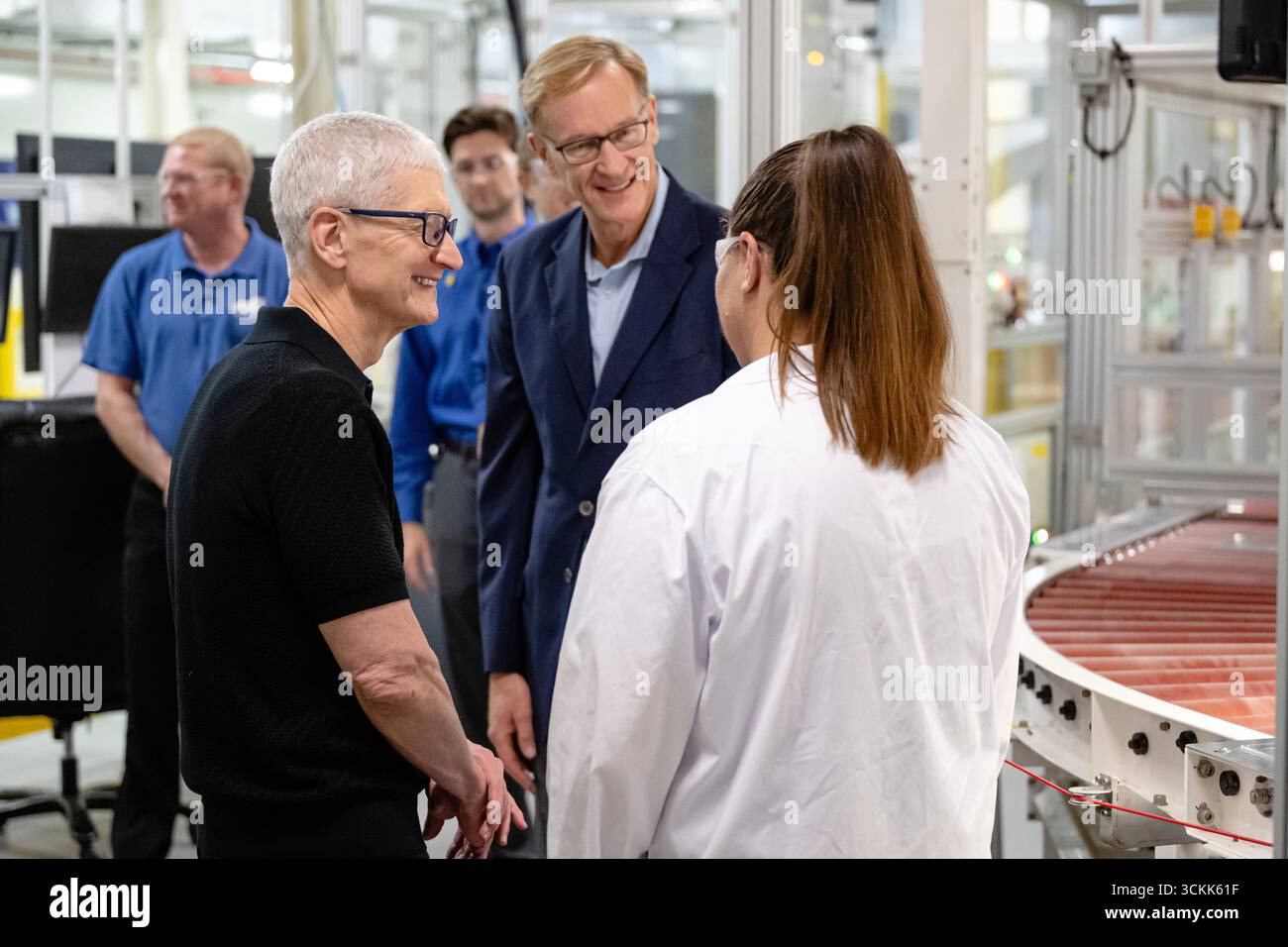 Apple CEO Tim Cook speaks to a quality control employee during a tour ...