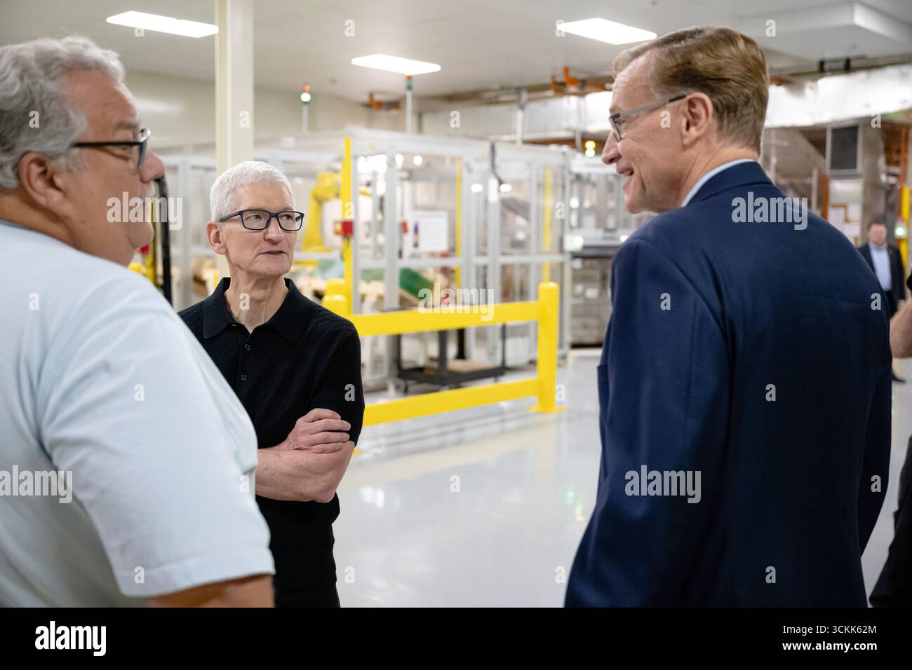 Apple CEO Tim Cook and Corning CEO Wendell Weeks speak to an employee ...