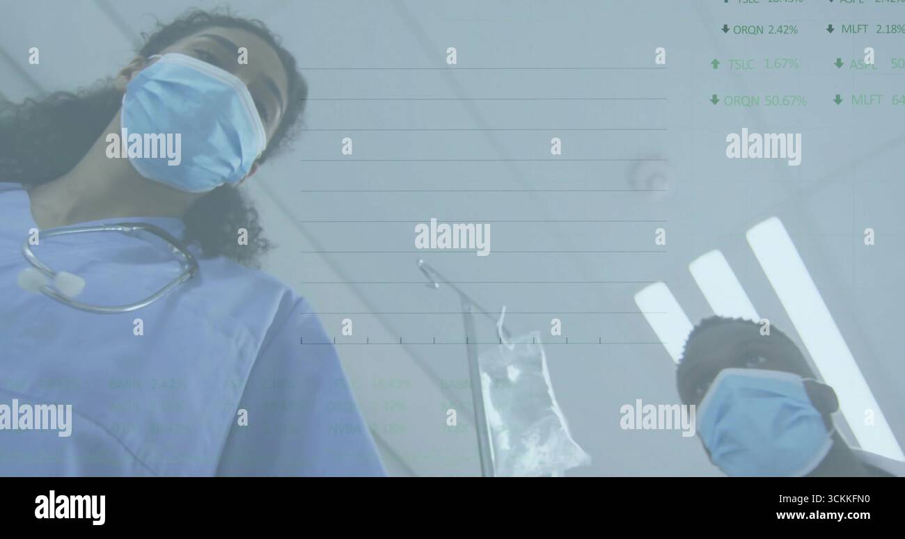 Examining staff leaning over patient in operating room, with IV bag ...