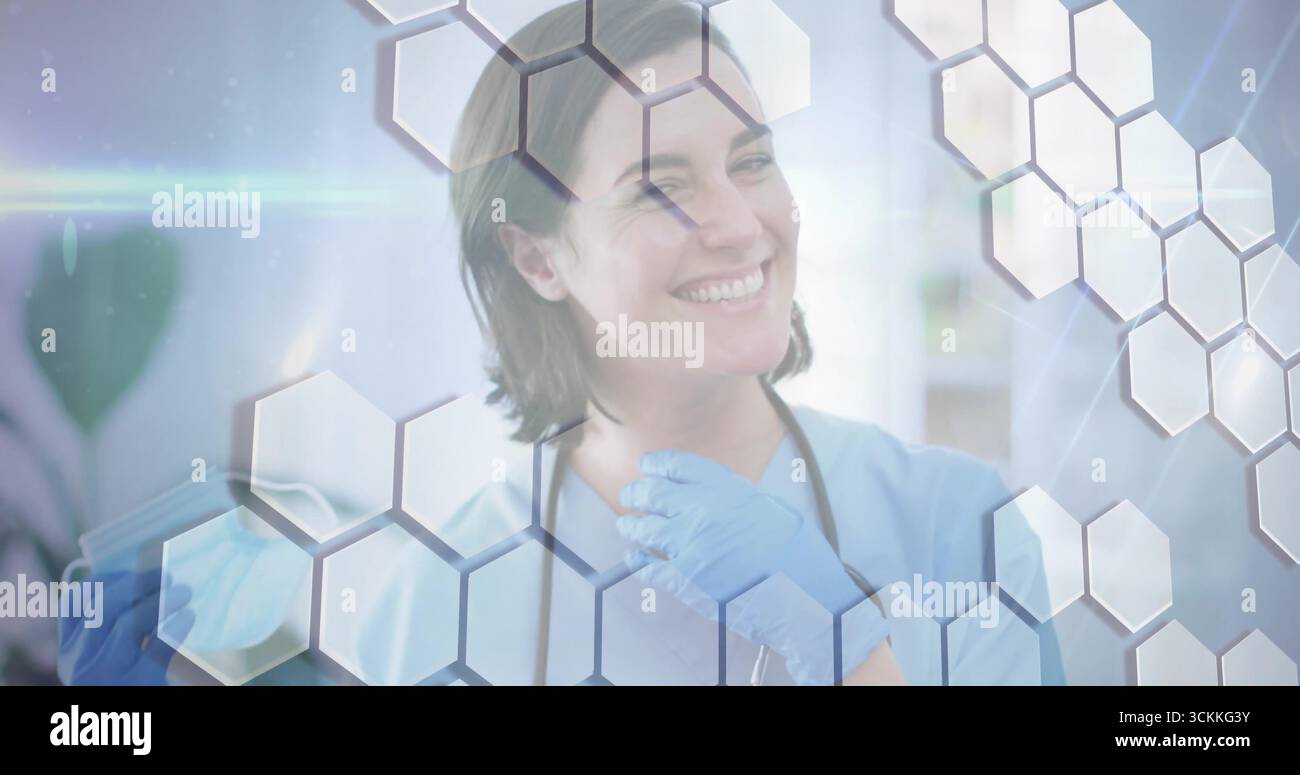 Smiling nurse in scrubs adjusting glove and holding cassette in exam ...
