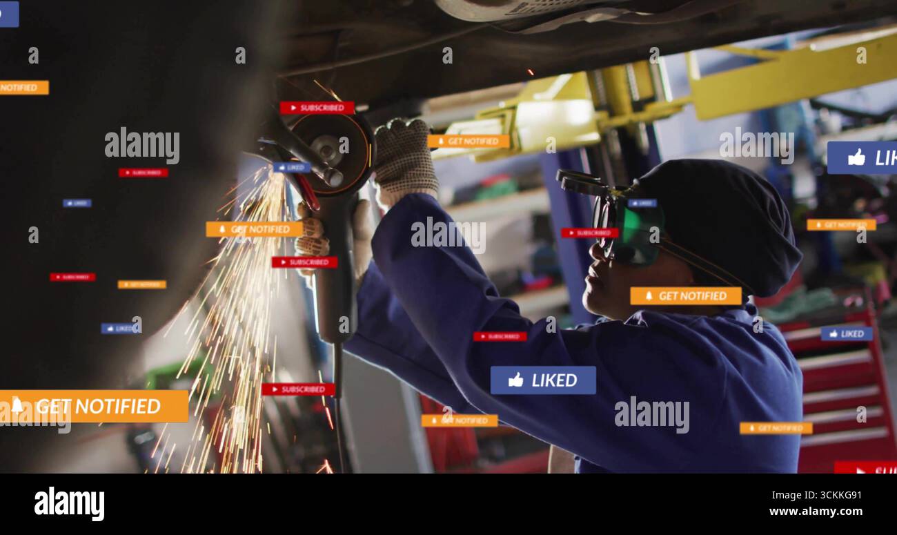 Mechanic wearing gloves grinding under chassis in workshop, with angle ...