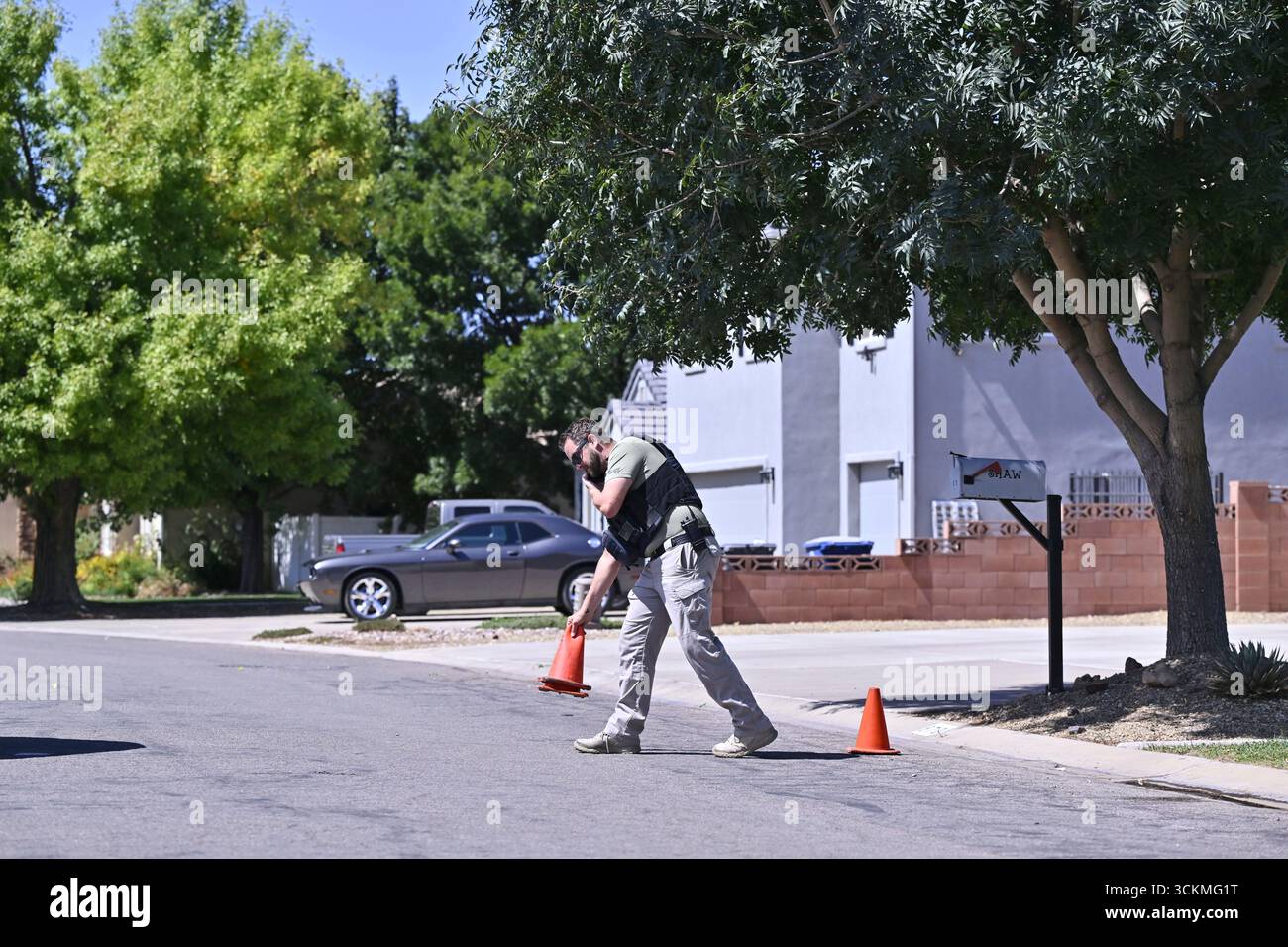 A law enforcement official moves a cone outside the family home of ...